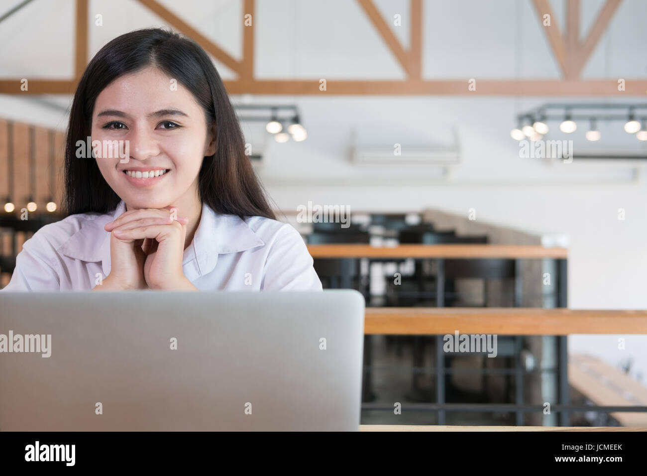 asiatische junge weibliche Geschäftsfrau mit Laptop-Computer am Tisch ...