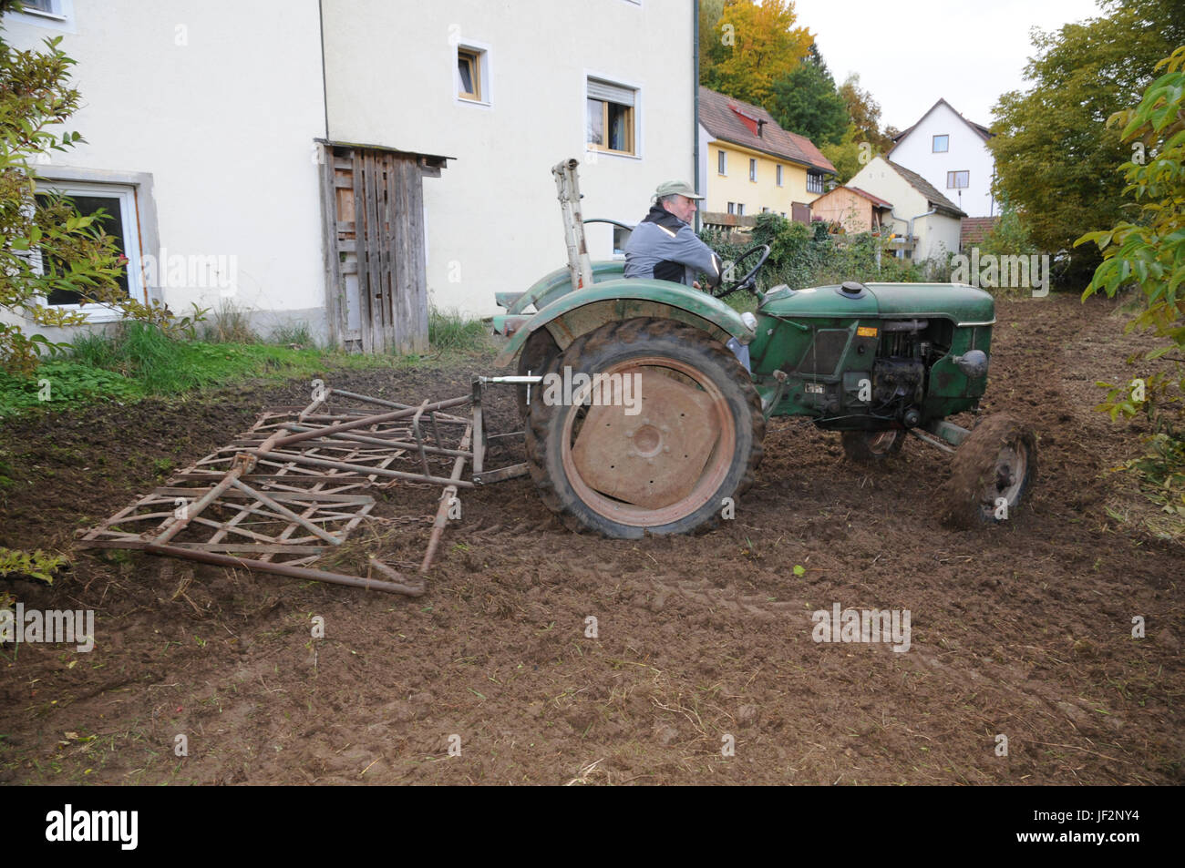Die Eggen Boden mit alten Traktor Stockfotografie - Alamy