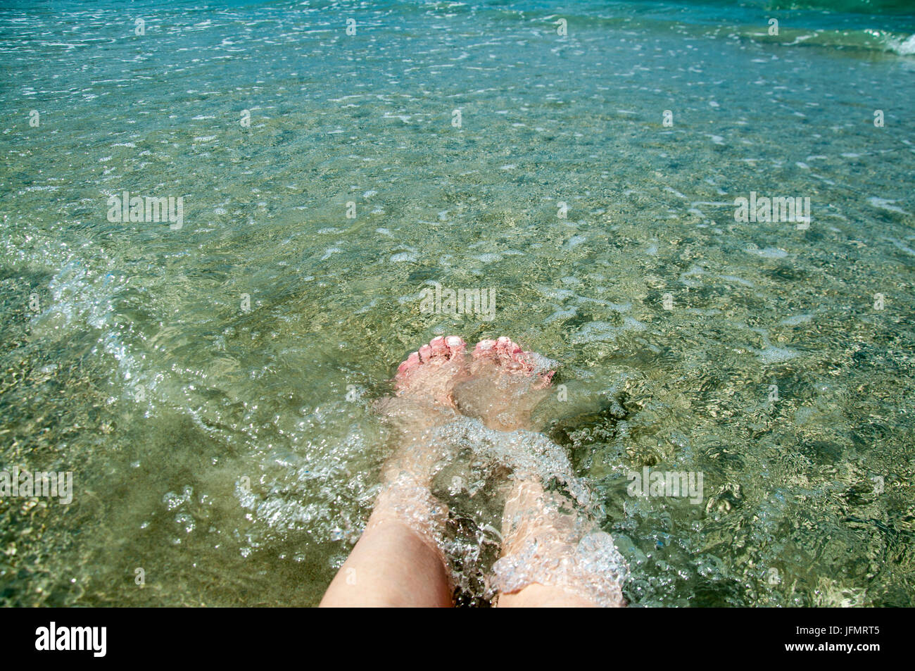 Die Beine des Mädchens in transparenten Meerwasser am Strand ...