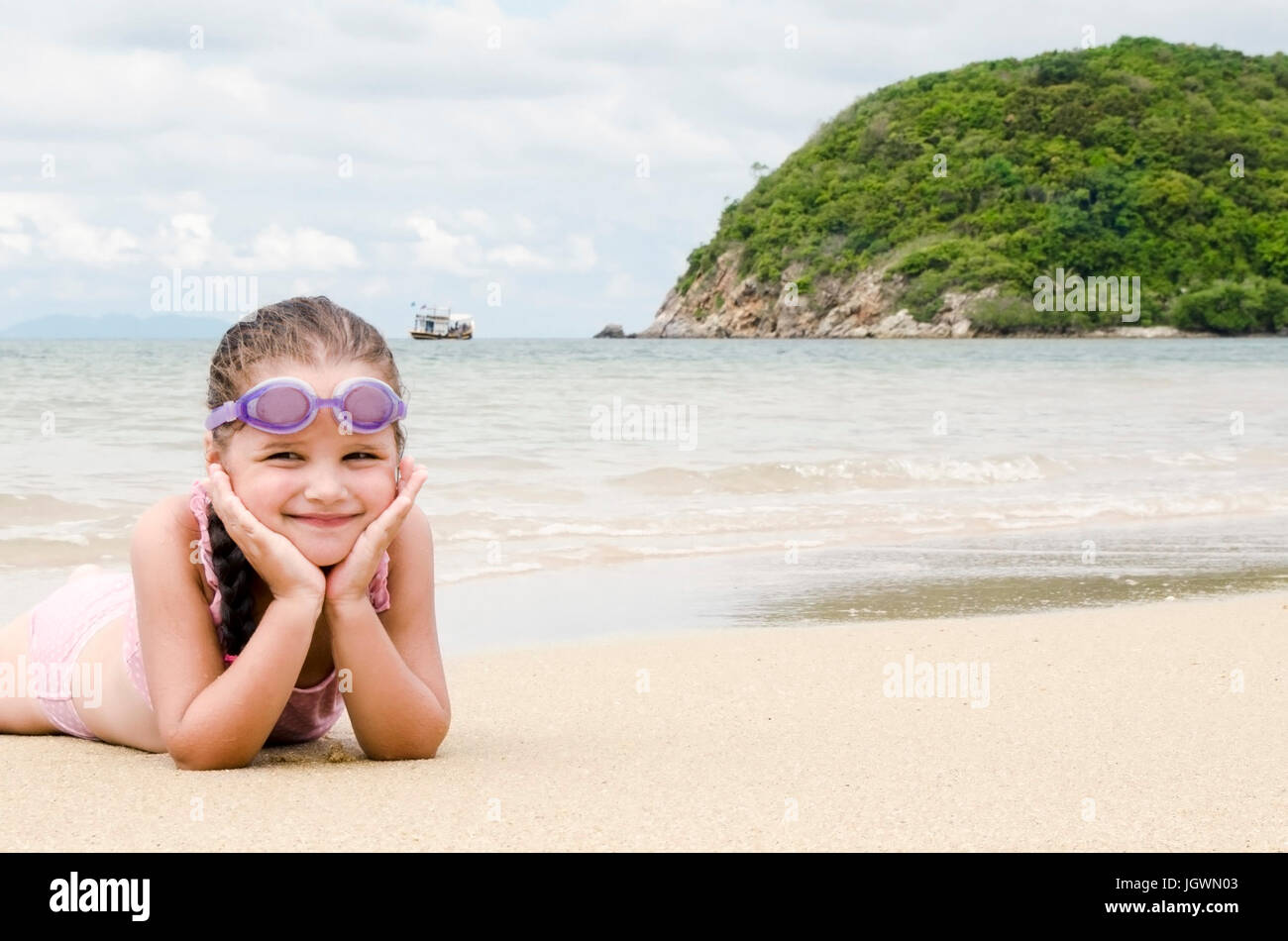 Glückliche kleine Mädchen liegen auf dem Sand am Strand weibliche ...