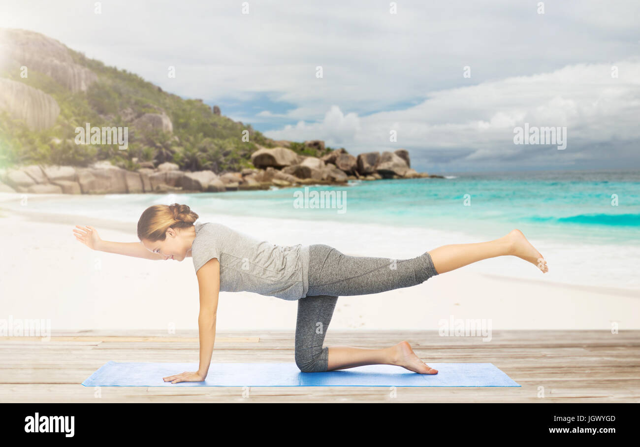 Frau beim Yoga bei der Abwägung der Tabelle Pose am Strand ...