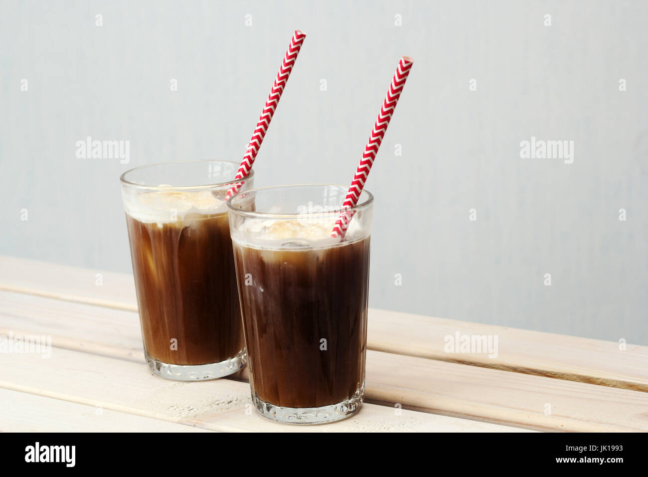 zwei Gläser kalter Kaffee mit Eis mit einem cocktail Stroh auf einem ...