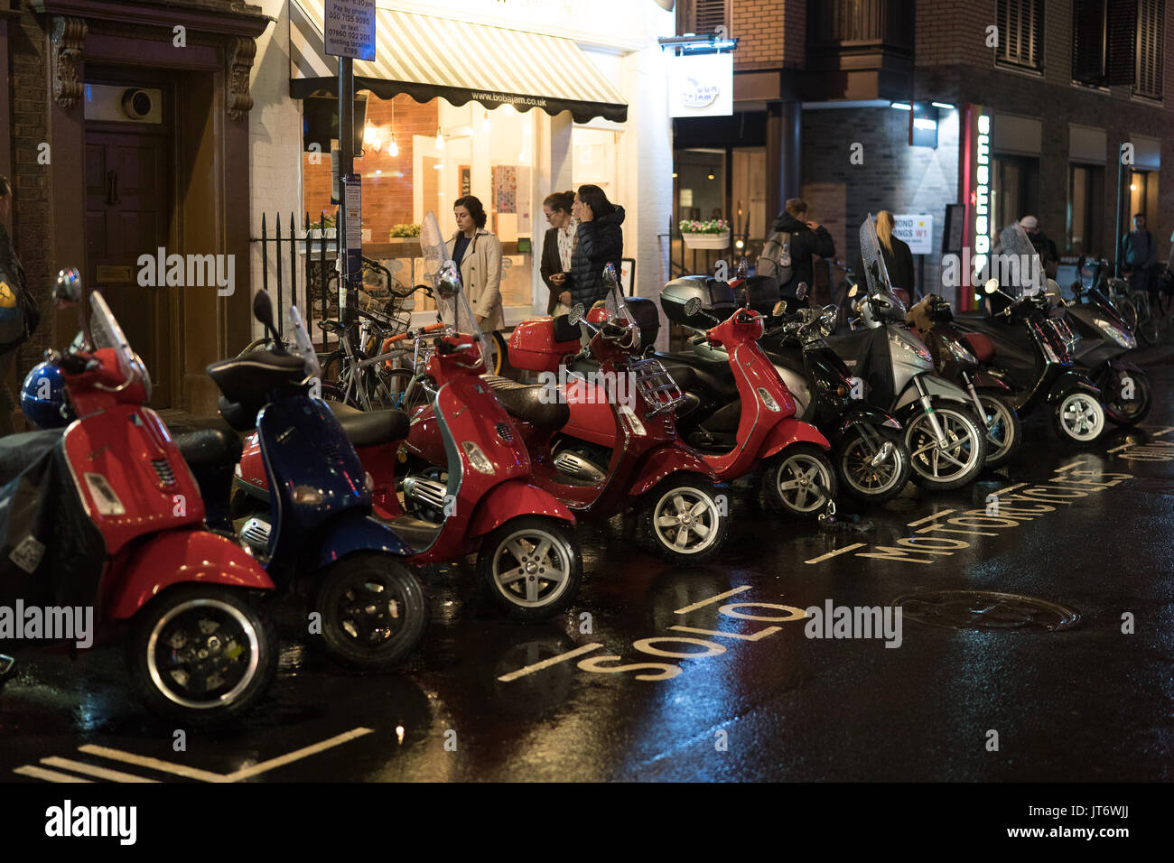 Blick auf eine Reihe von Mopeds auf der Dean Street in Soho in London ...