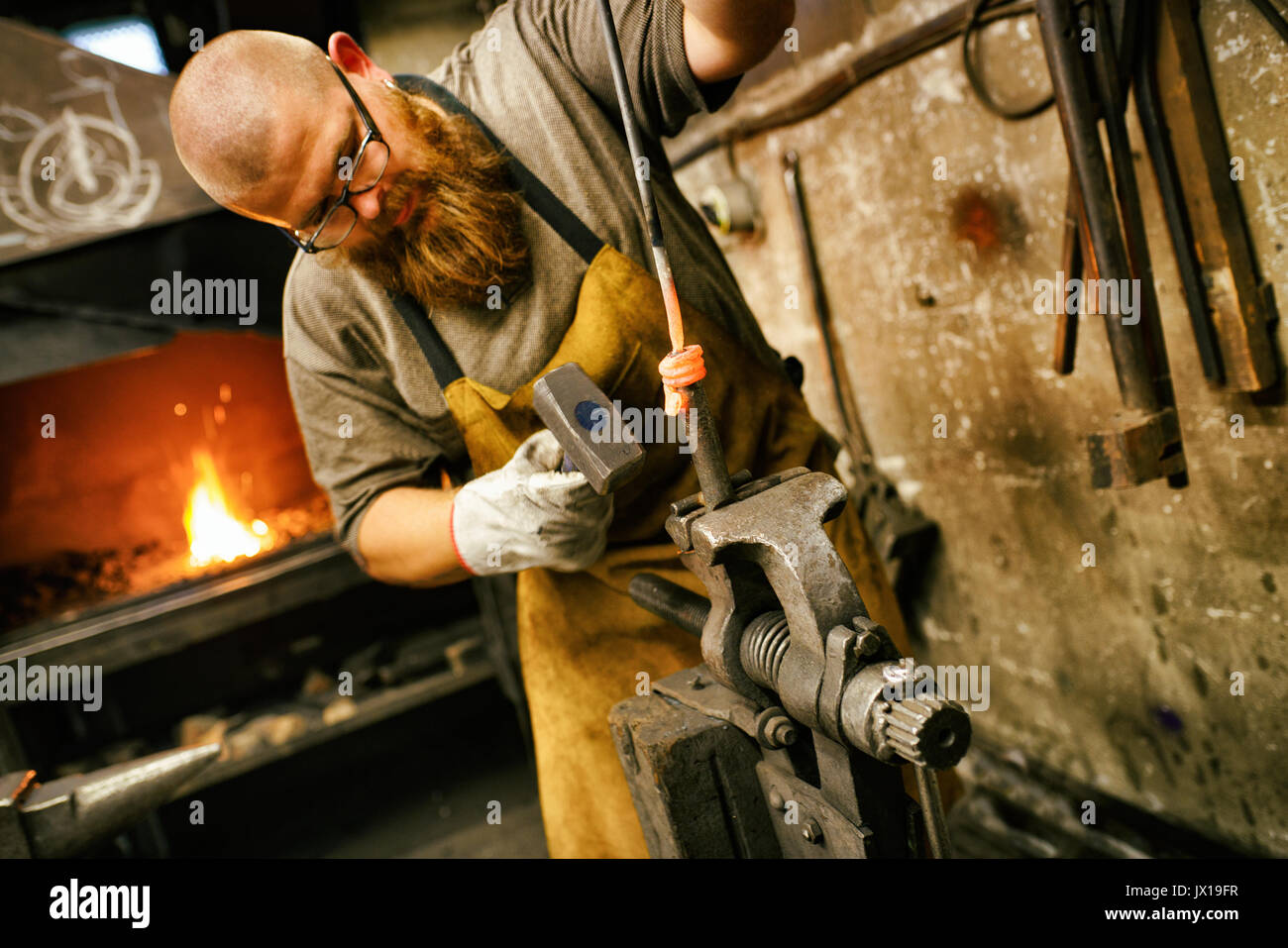 Schmied, der mit hammer und eisen arbeitet -Fotos und -Bildmaterial in ...