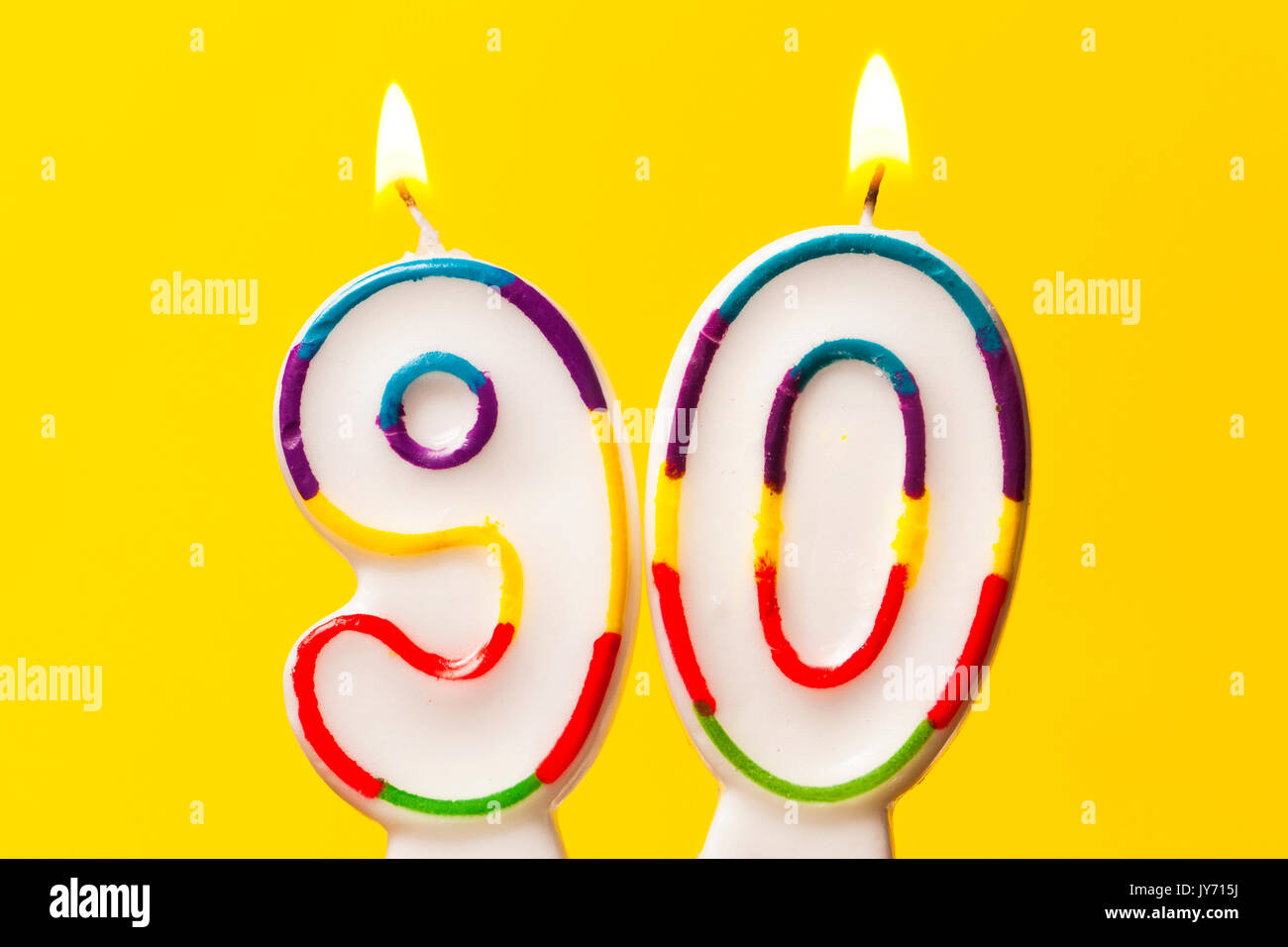 Nummer 90 Geburtstag Kerze gegen einen hellen Hintergrund gelb ...