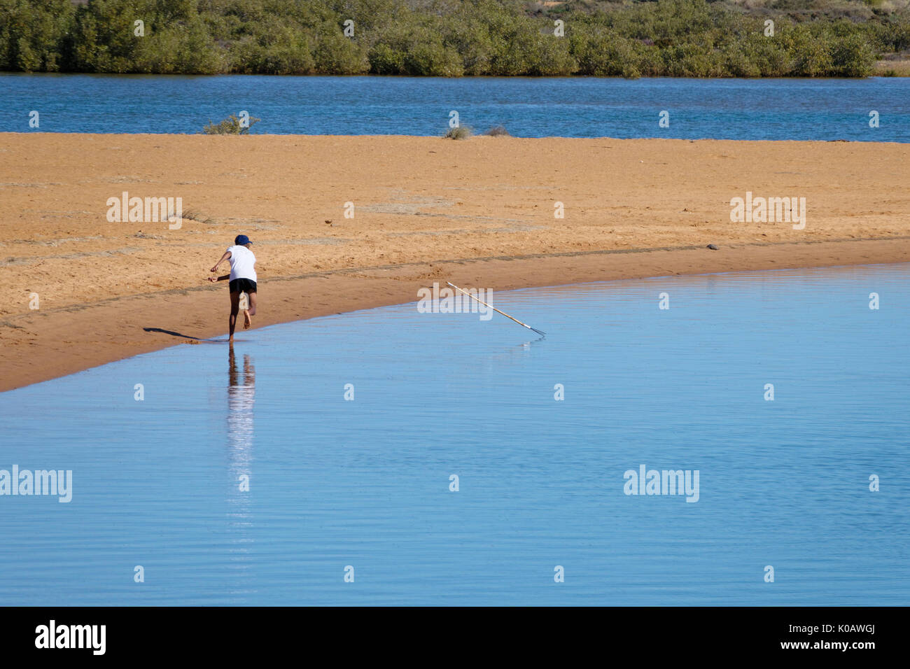 Junge Aborigines mann Speerwerfen in Wasser, Versuch, um Fische zu ...