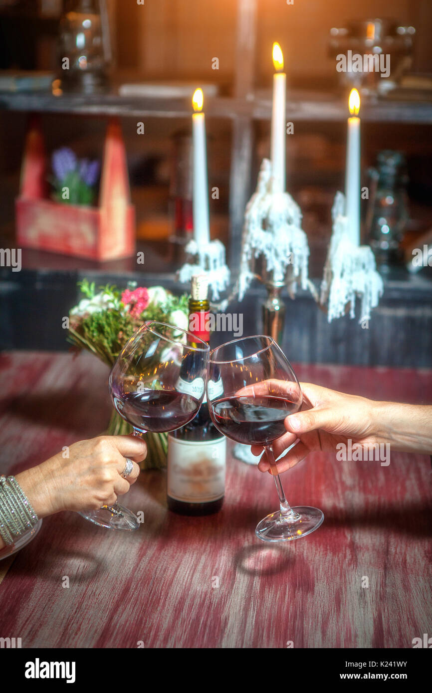 Romantisches Paar mit Gläser Rotwein auf ein Datum in ein gemütliches ...