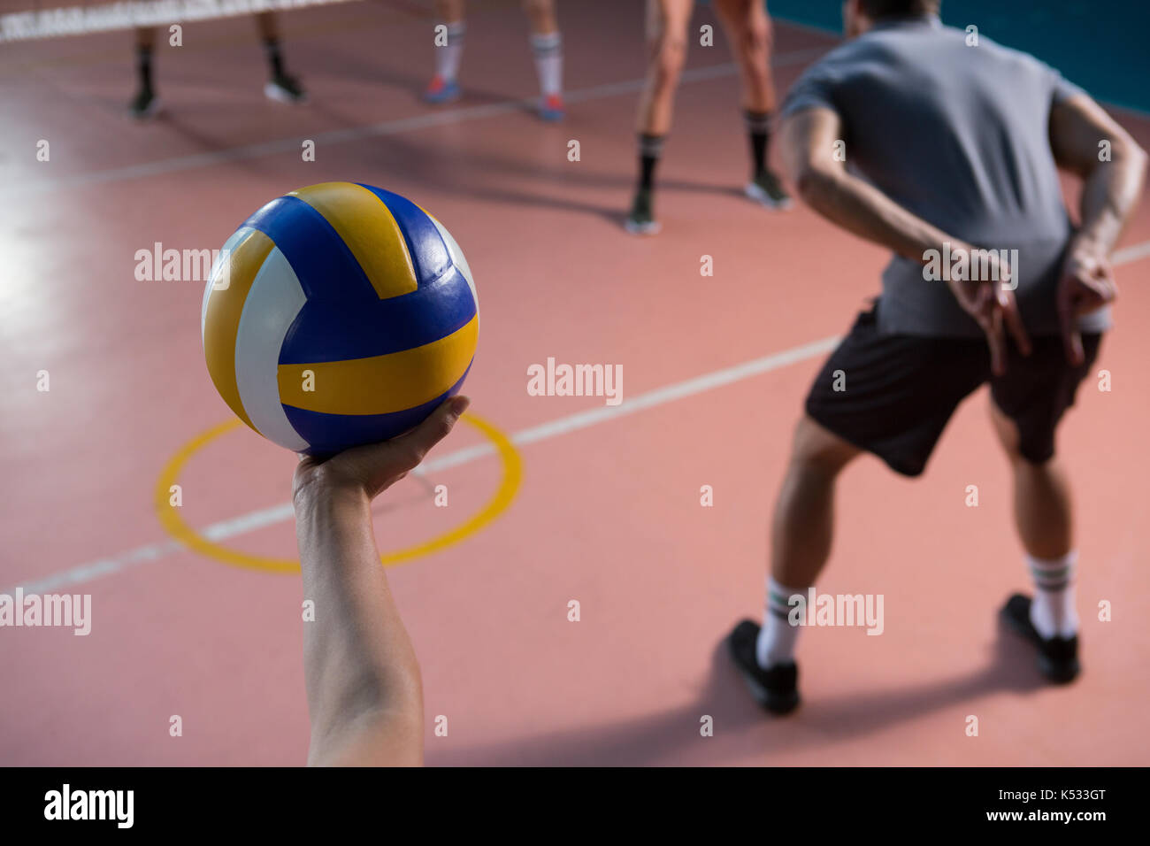 7/8 Hand der Spieler mit Volleyball durch Mannschaftskameraden am Hof ...