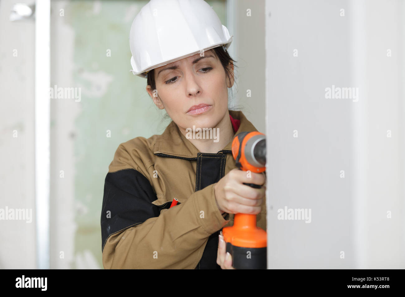Frau loch bohren wand -Fotos und -Bildmaterial in hoher Auflösung – Alamy