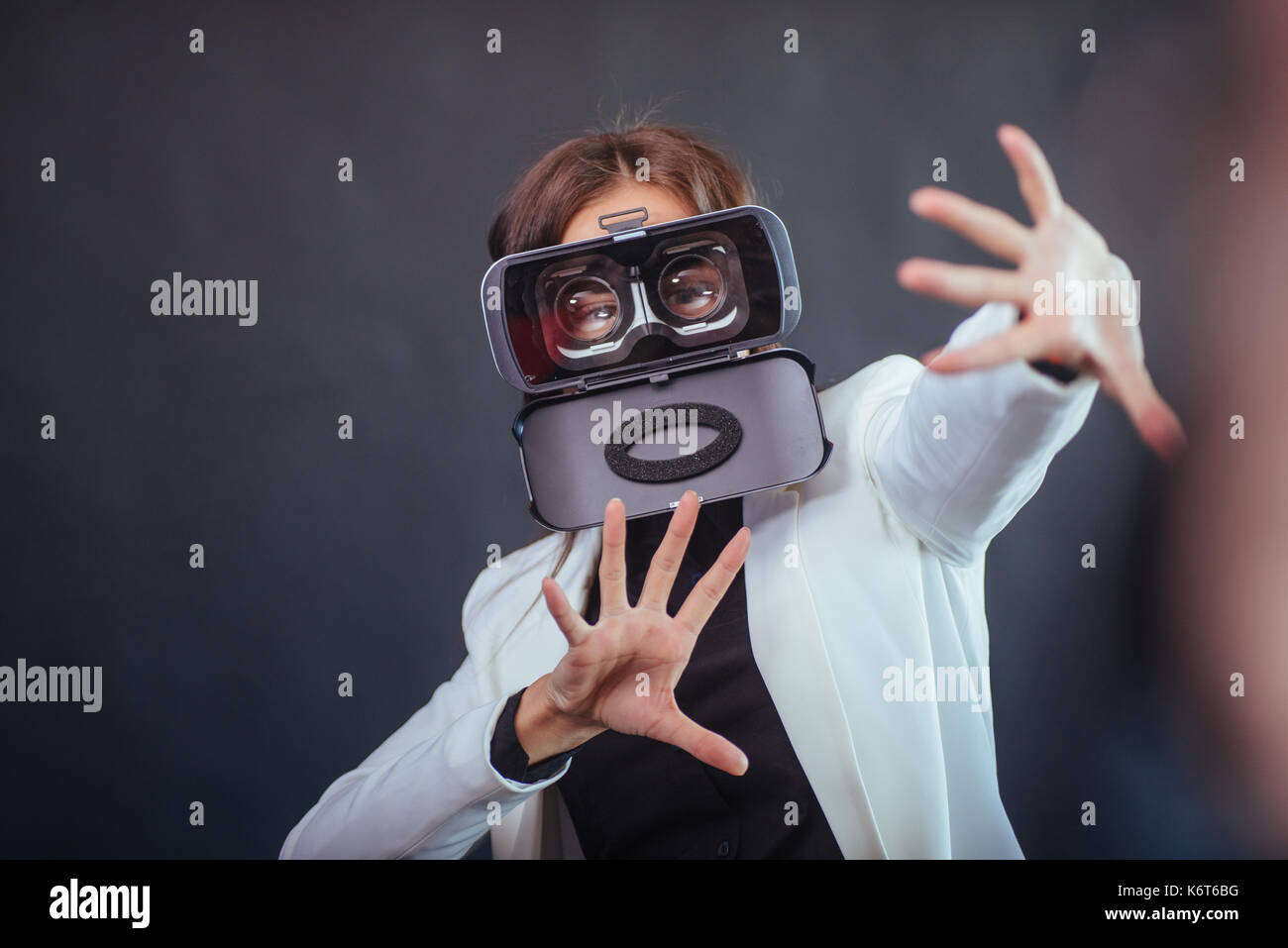 Glückliche Frau auf einem schwarzen Hintergrund im Studio erhält die ...