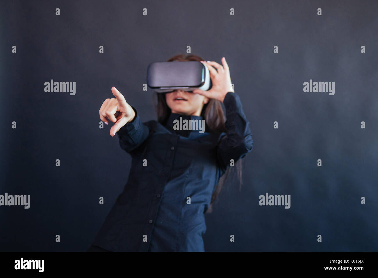 Glückliche Frau auf einem schwarzen Hintergrund im Studio erhält die ...