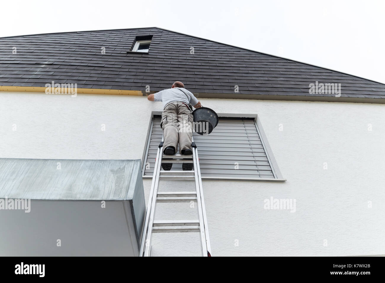 Gipser bleiben auf Leiter und Abdeckung der Dach-Unterseite mit einer ...