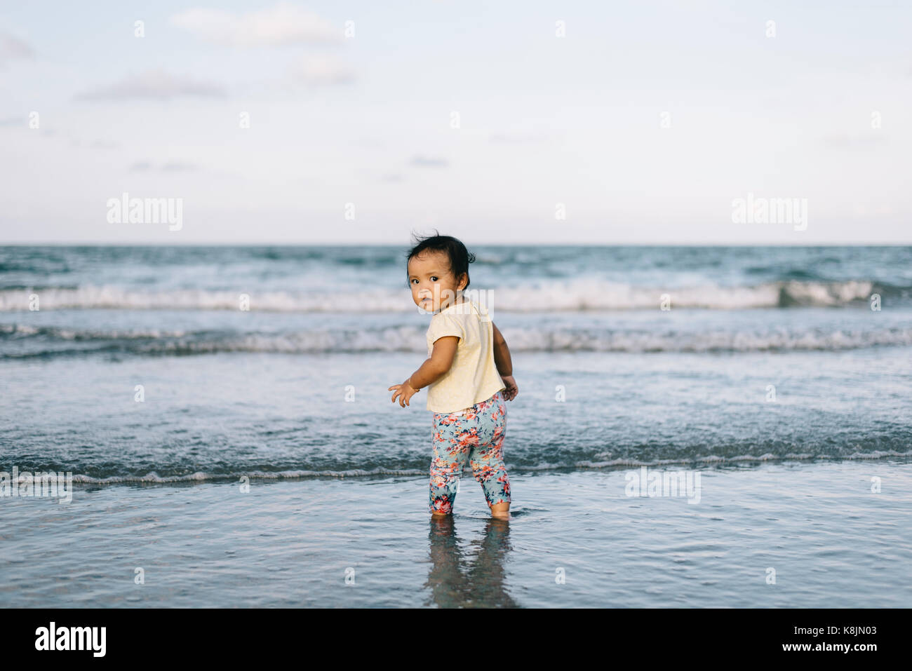 Baby oder Kleinkind am Strand Wellen zum ersten Mal neugierig machen ...