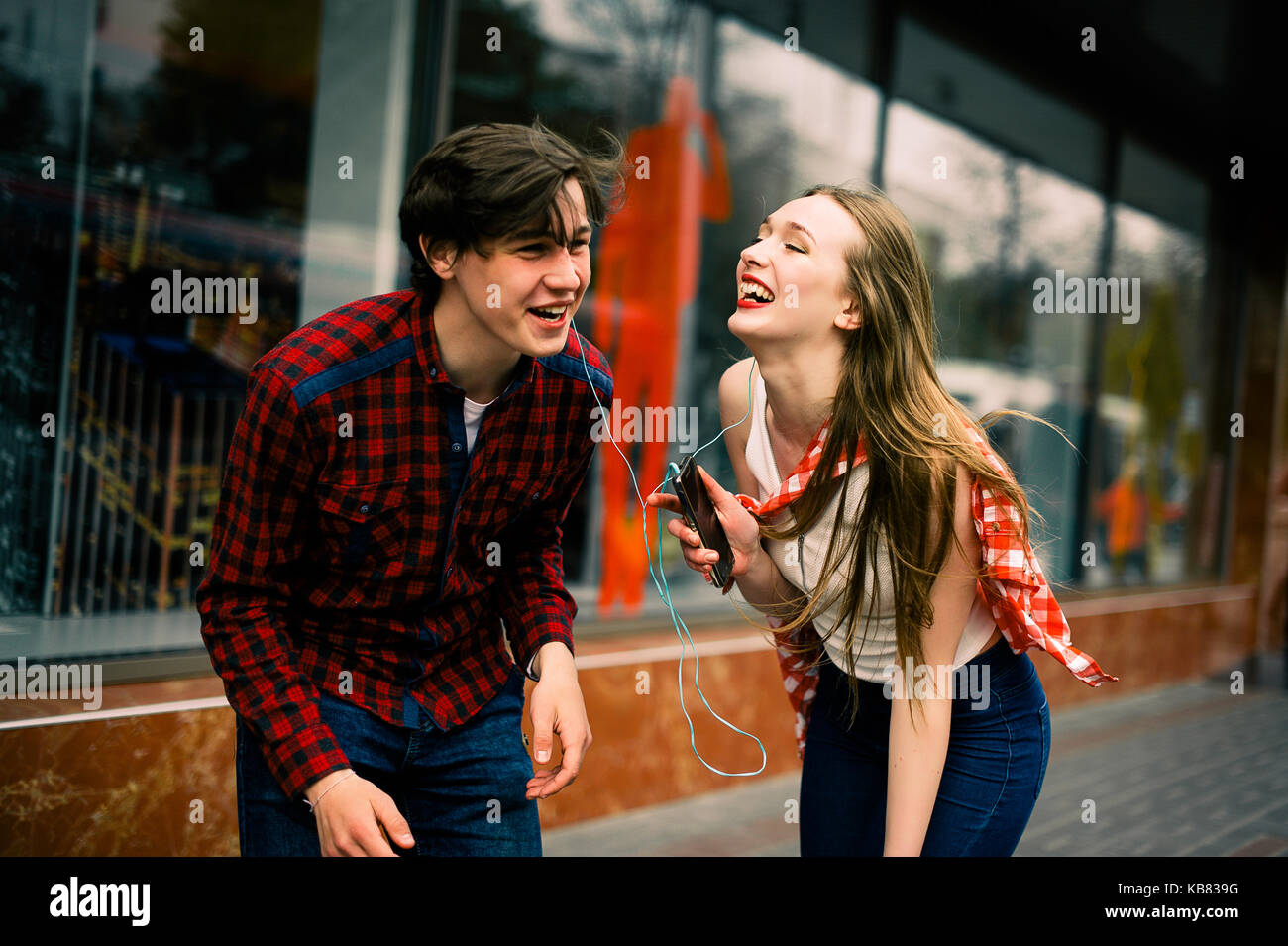 Vier Glückliche trendige Teenager Freunde zu Fuß in die Stadt, reden ...