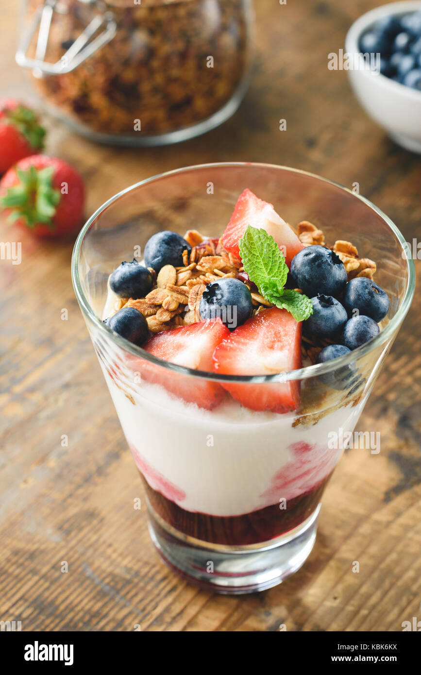 Joghurt mit Müsli, Blaubeeren und strawberies in Glas auf Holztisch ... Joghurt mit Müsli, Blaubeeren und strawberies in Glas auf Holztisch ...