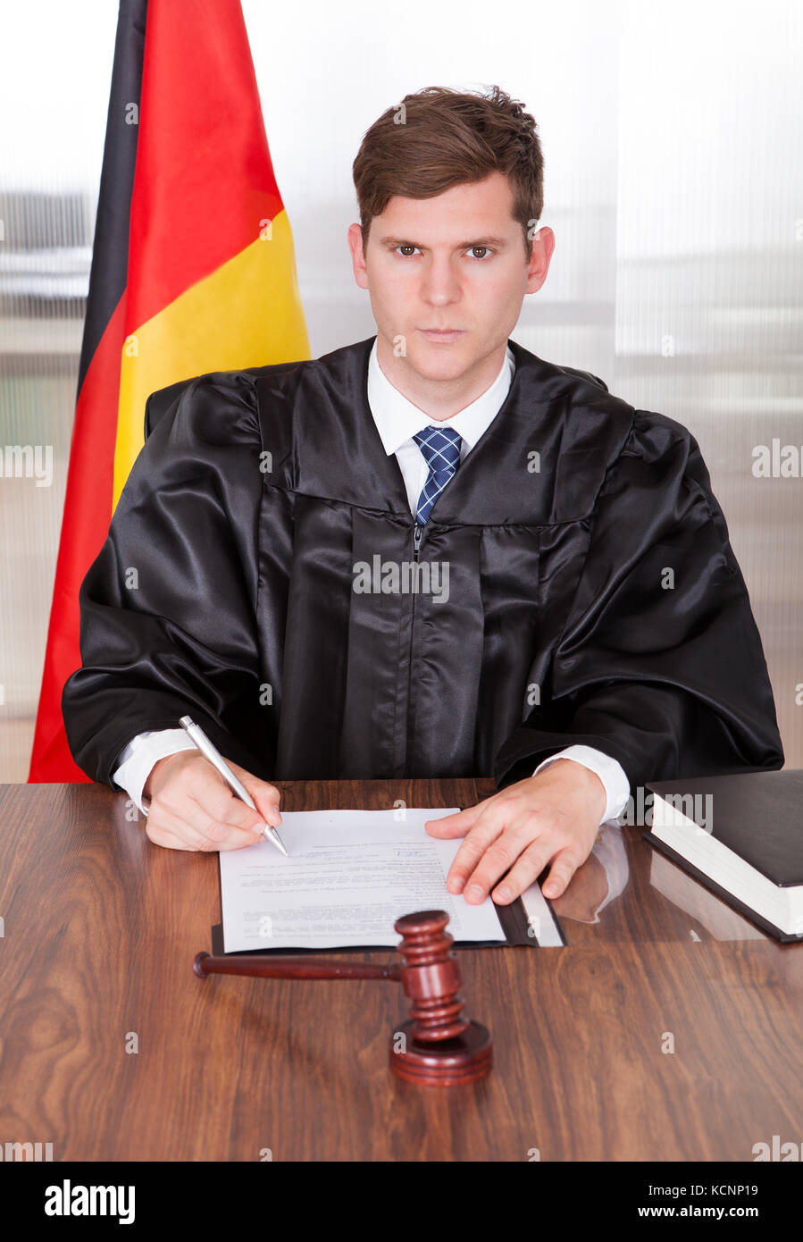Männliche Richter mit dem Hammer und buchen Sie im Gerichtssaal ... Männliche Richter mit dem Hammer und buchen Sie im Gerichtssaal ...