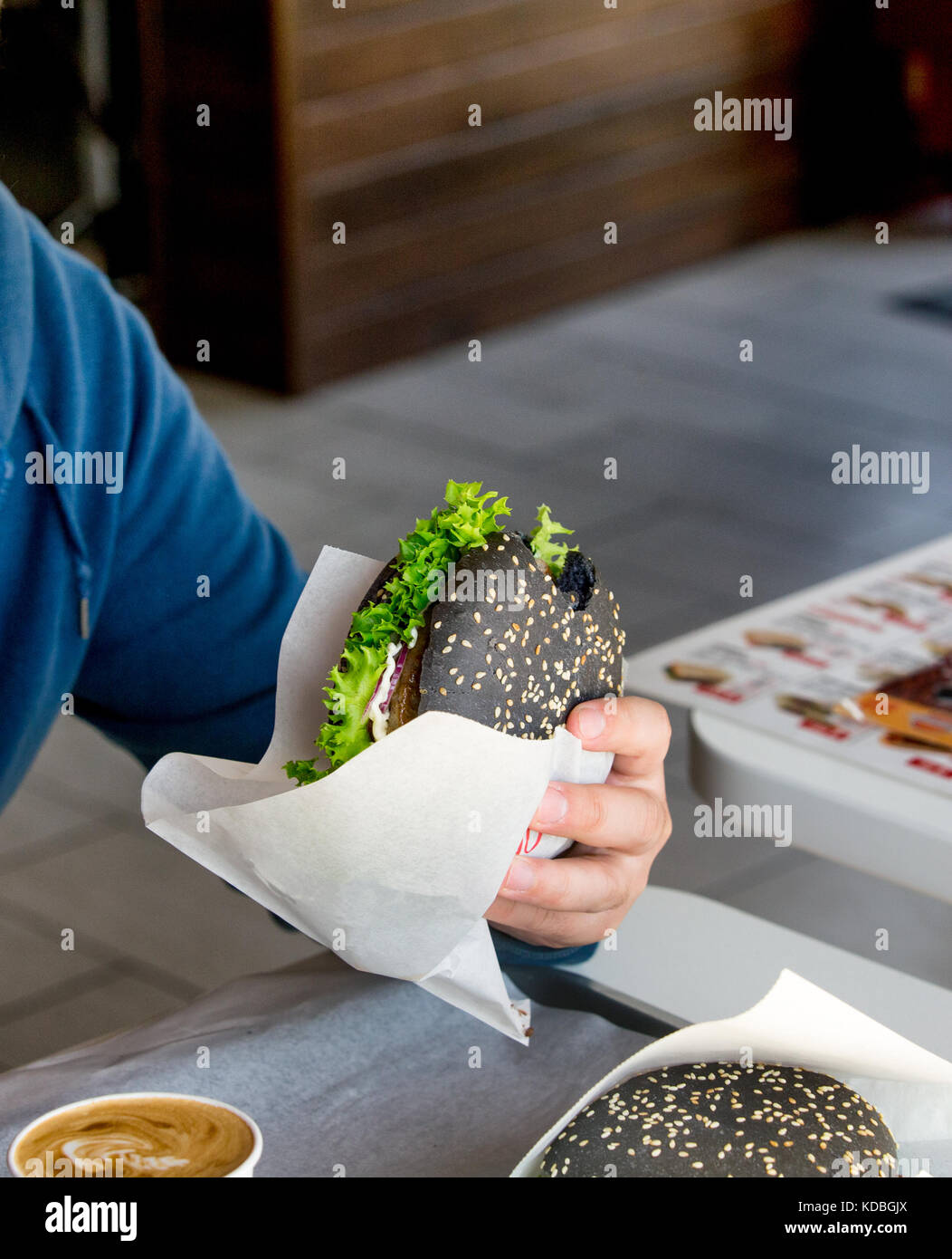 Schwarz Burger mit einem Schnitzel und ein Blatt Salat, Käse, Sesam, in ...