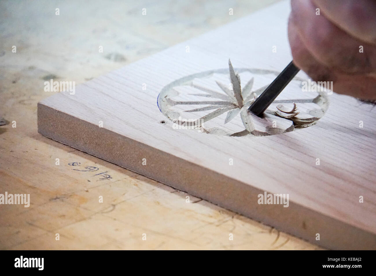 Ein Mann die Gravur ein Stück Holz mit einem Hammer und Meißel ...