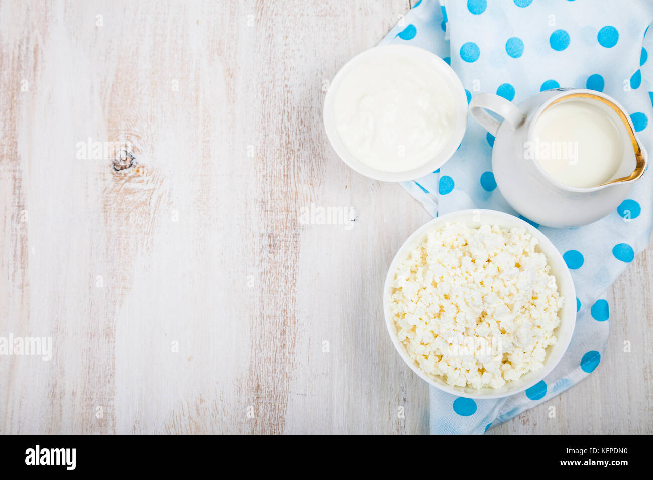 Quark, saure Sahne und Milch auf einem Holztisch, Ansicht von oben ...