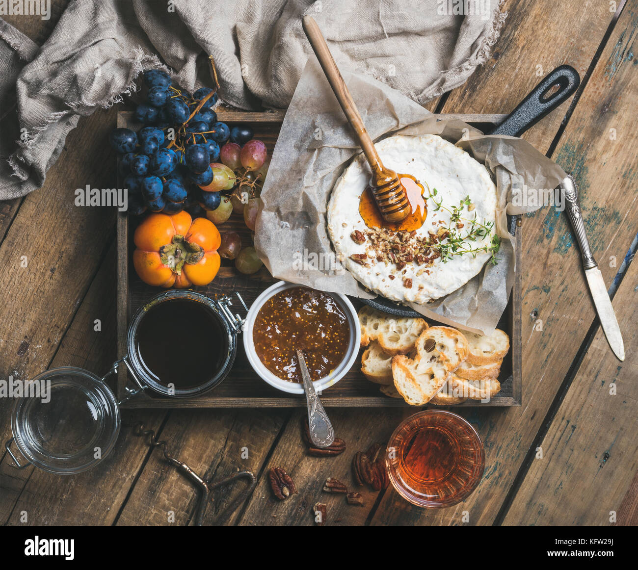 Camambert mit Honig, Nüsse, Kräuter, Obst und Wein Stockfotografie - Alamy