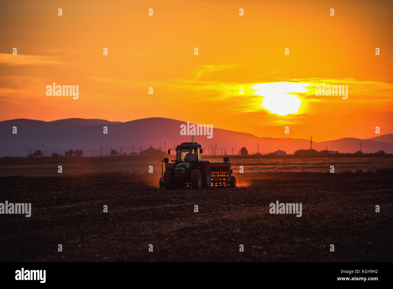 Bauer mit Traktor säen ernten am Feld auf Sonnenuntergang ...
