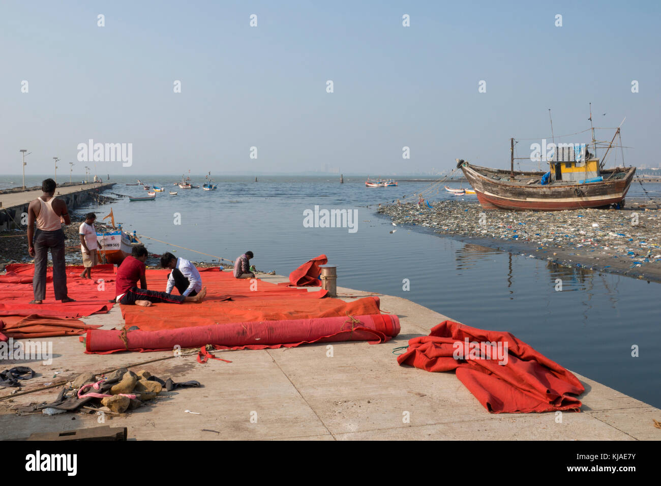 Menschen, die außerhalb von Khar Danda in Mumbai, Indien, an Textilien ...