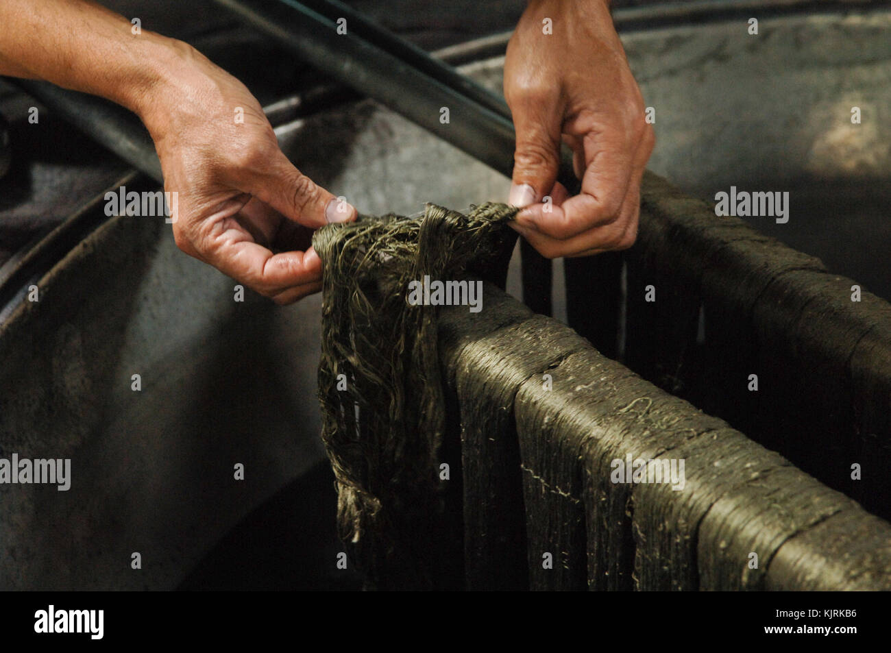 Malerei Fäden und Garne. männliche Hände paint das Tuch in den Trog ...