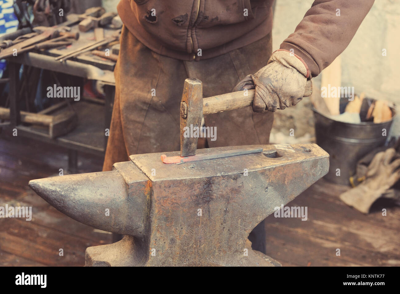 Schmied Arbeiten aus Metall mit einem Hammer auf dem Amboss in der ...
