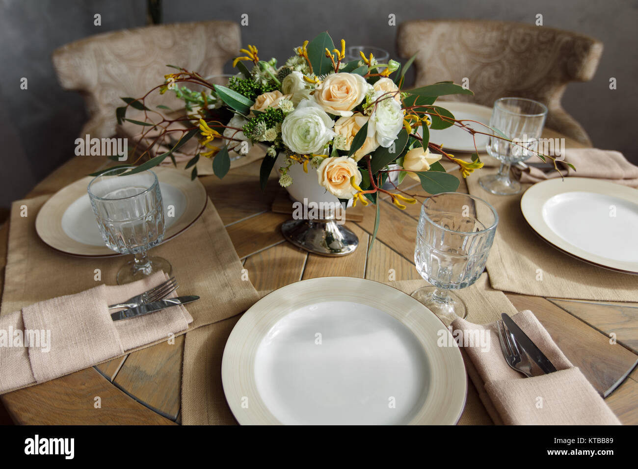 Runder Esstisch aus Holz mit Blumenstrauß eingerichtet Stockfotografie ...