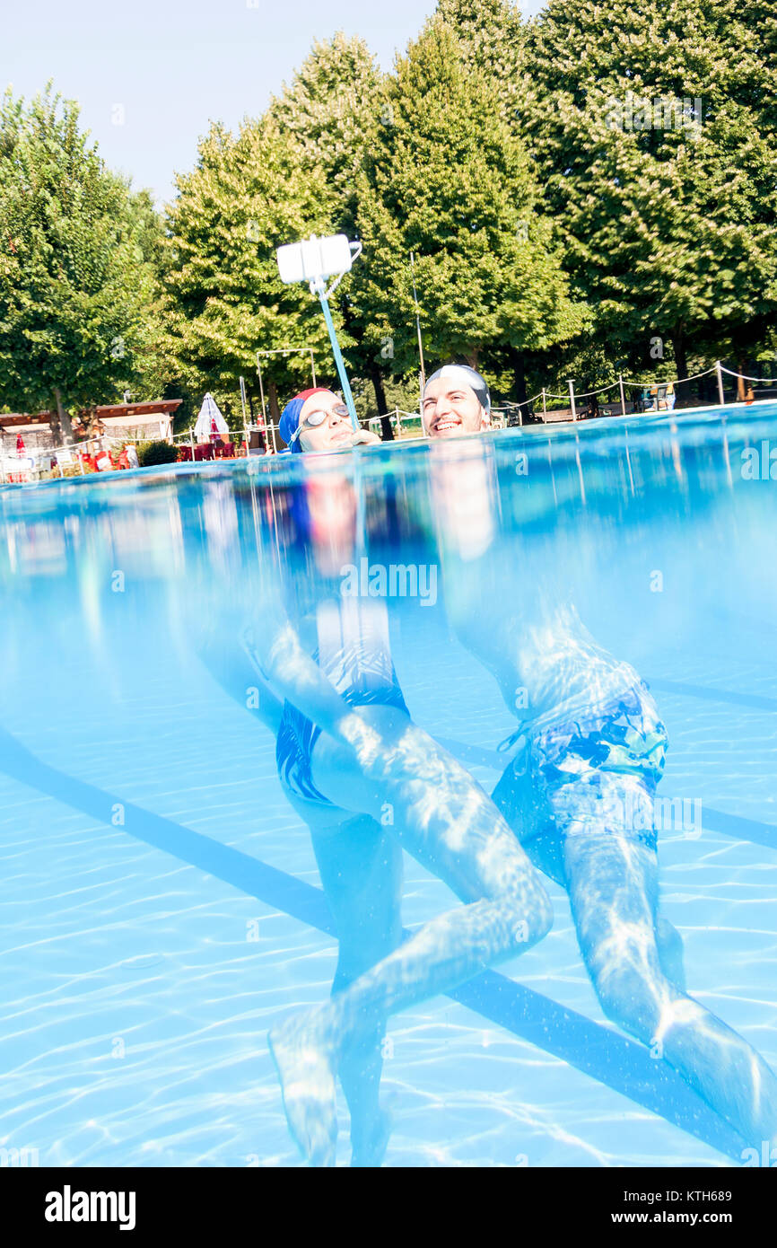 Junge liebende Paar nimmt eine selfie unter Wasser in den Pool. Konzept ...