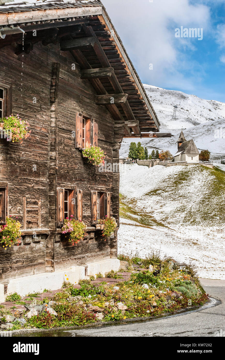 Typische Schweizer Blockhaus im Bergdorf Arosa mit dem Bergkirchli im ...