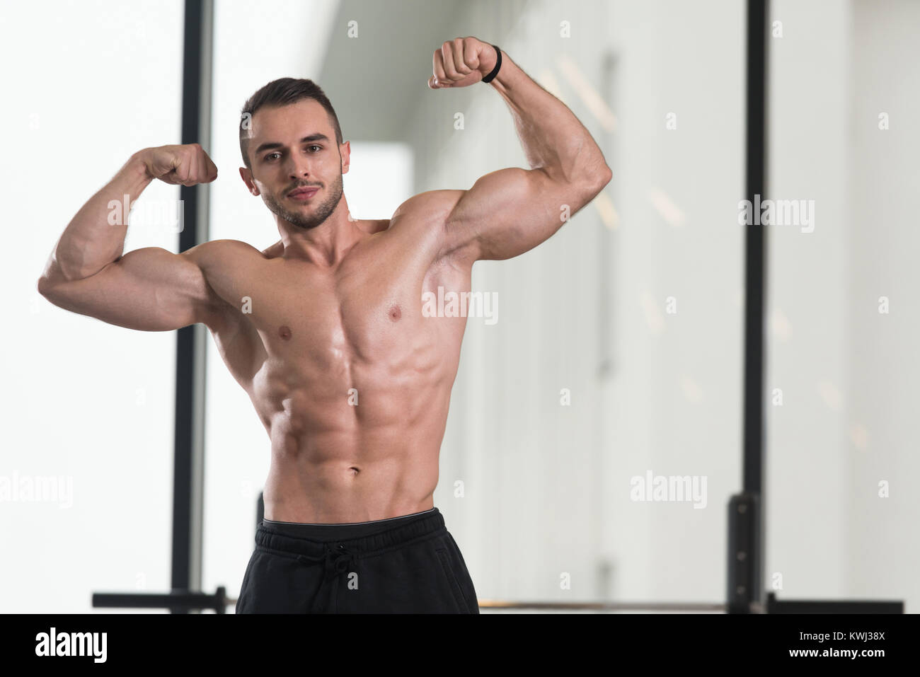 Portrait eines jungen Fit körperlich Mann zeigen, dass seine gut ...