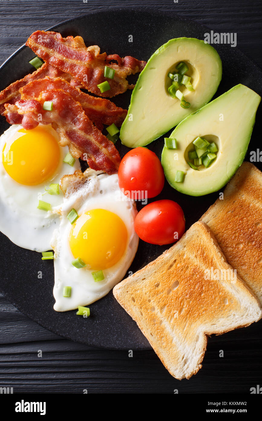 Hausgemachte Spiegeleier mit Speck, Zwiebel, Avocado, Toast und Tomaten ...