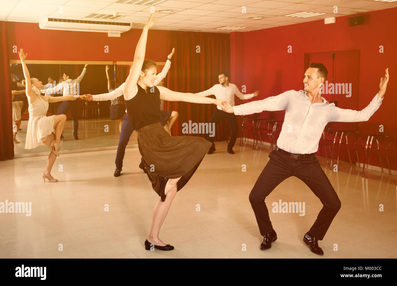 Junge gerne Fröhliche positive Leute tanzen Rock-and-Roll in Paaren ...