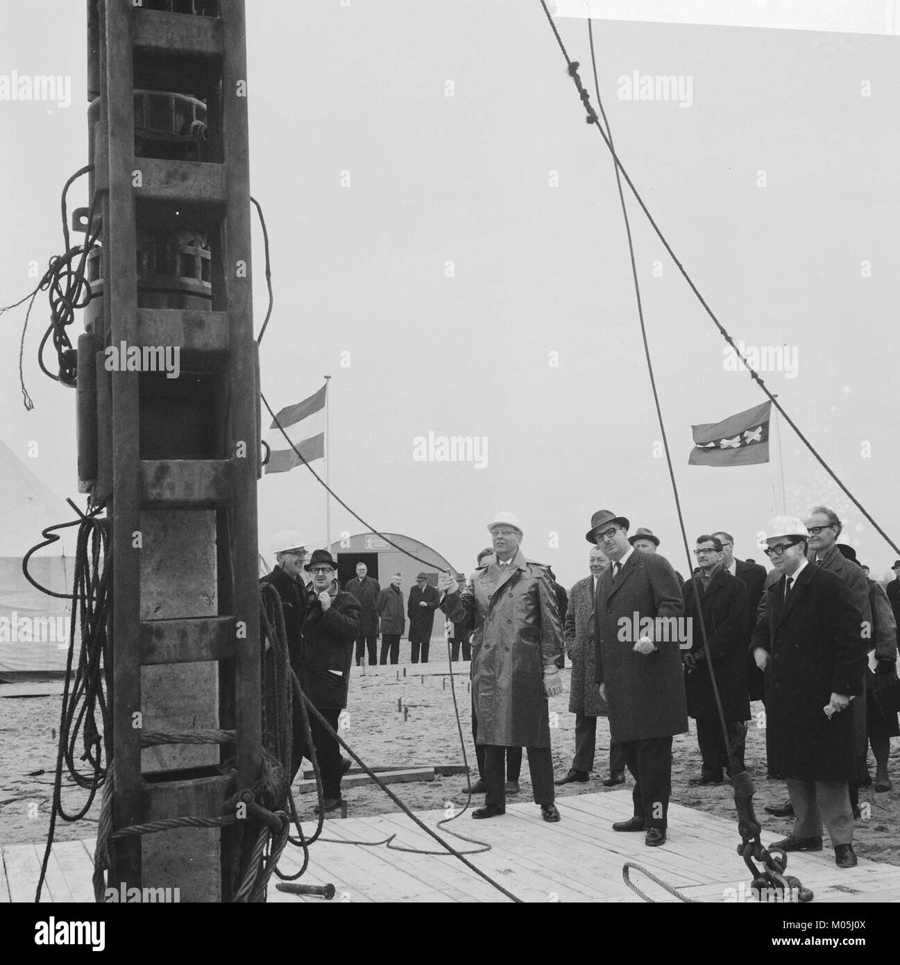 Das Bild zeigt Bürgermeister Van Hall, der den ersten Pfahl im ...