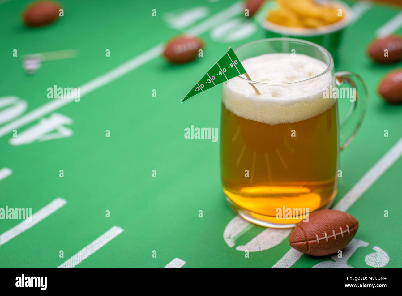 Große Tasse kaltes Bier am Tisch bei Big Game Day Feier Stockfotografie ...