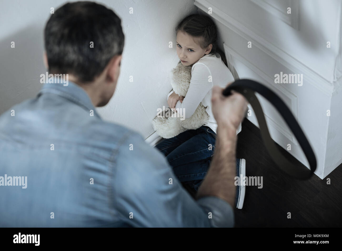 Angst Mädchen in der Ecke sitzend mit Teddybär Stockfotografie - Alamy