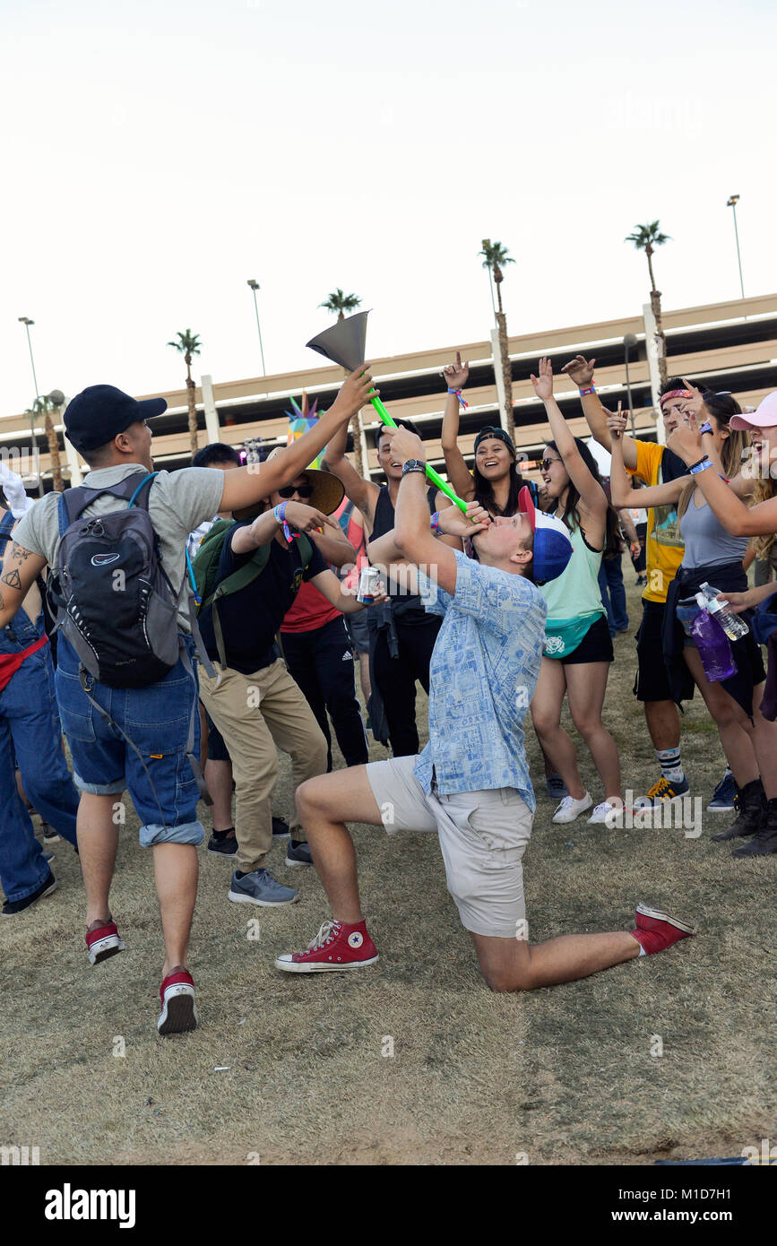 Junger Mann Bier trinken durch einen Trichter und Schlauch, ein so ...