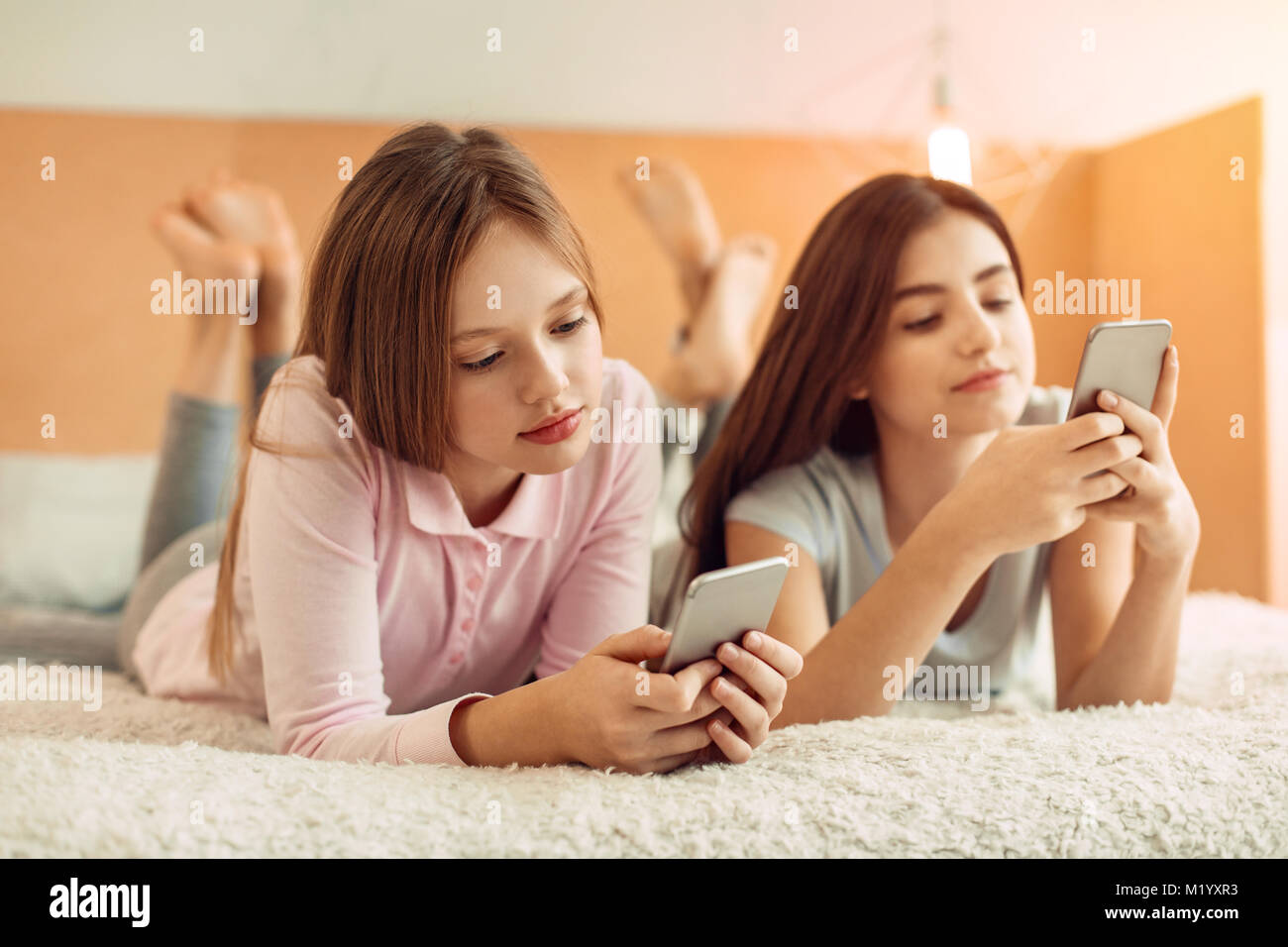 Hübsches Mädchen im Teenageralter, um ihre Telefone geklebt Stockfotografie - Alamy