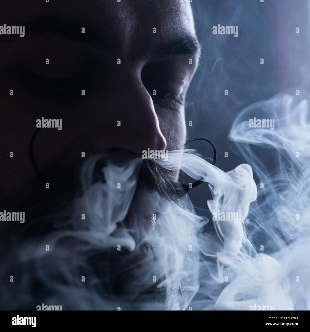 Mann mit Bart und Mustages Vaping eine elektronische Zigarette. Vaper ...