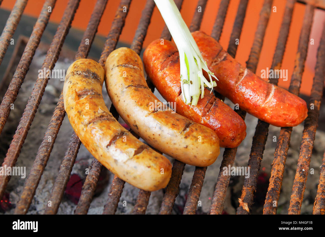 Nahaufnahme von grillen Würstchen auf Grill mit einem langen, weißen ...