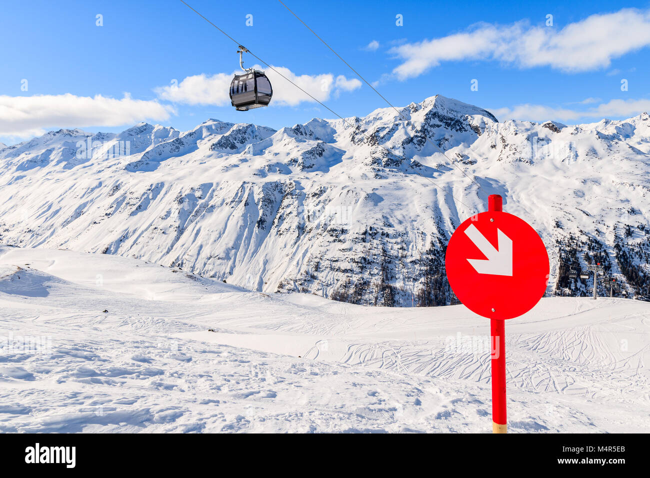 Rote Zeichen auf der Skipiste und der Gondel Fahrzeug auf Hebebühne in ...