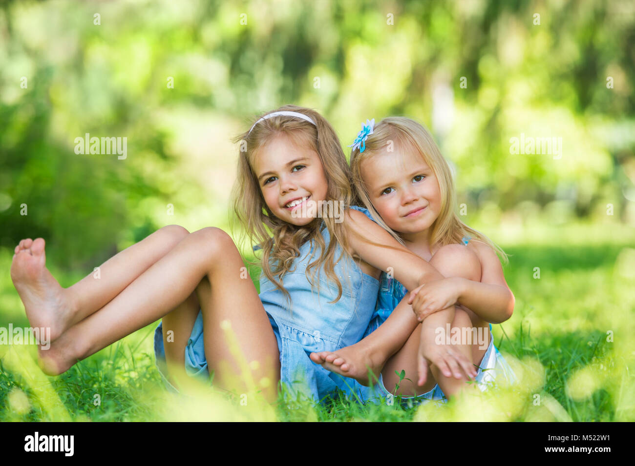 Zwei kleine nette Mädchen auf der Wiese im Park Stockfotografie - Alamy
