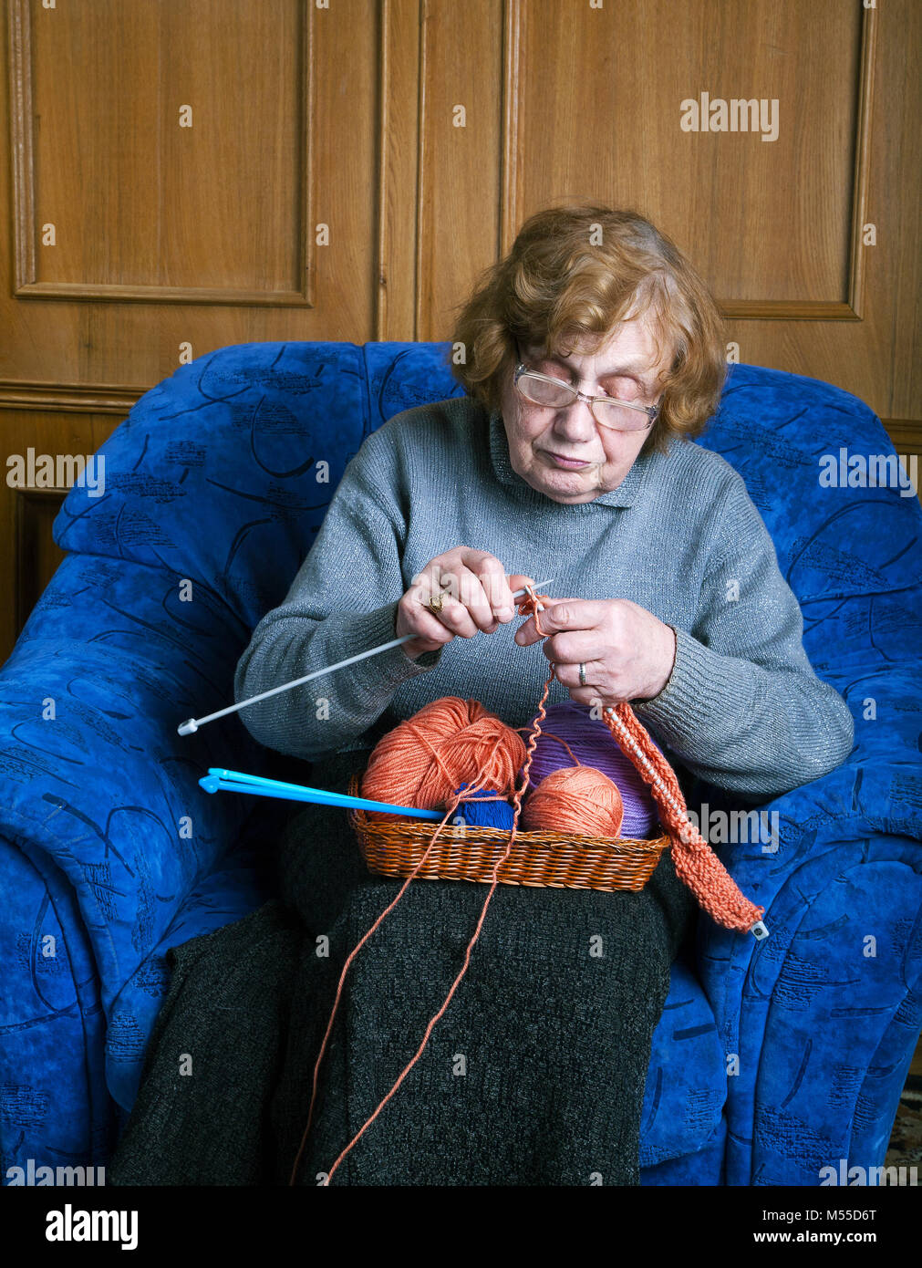 Die alte Frau sitzt in einem Sessel stricken Stockfotografie - Alamy