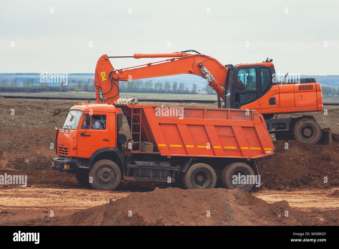 Red wxcavator laden Kipper am Bau der Straße Stockfotografie - Alamy