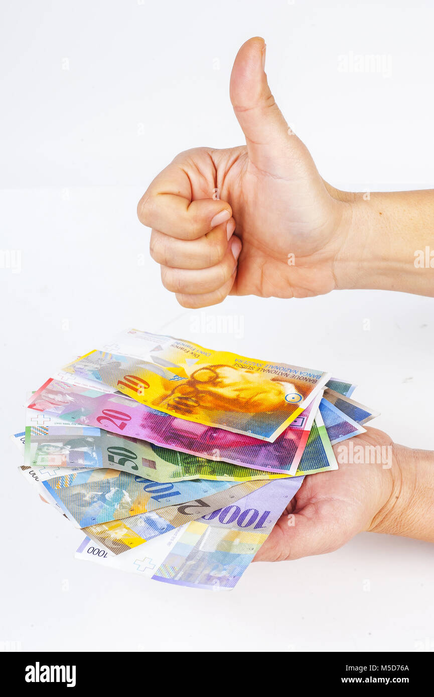 Weibliche Hand, die Banknoten in Schweizer Franken und in weiblicher Hand, Daumen hoch Zeichen ...