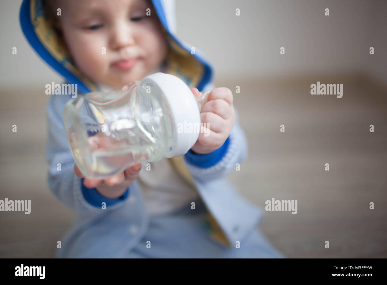 Kleinkind am Tisch und trinken Milch sitzen. Wasser Stockfotografie - Alamy