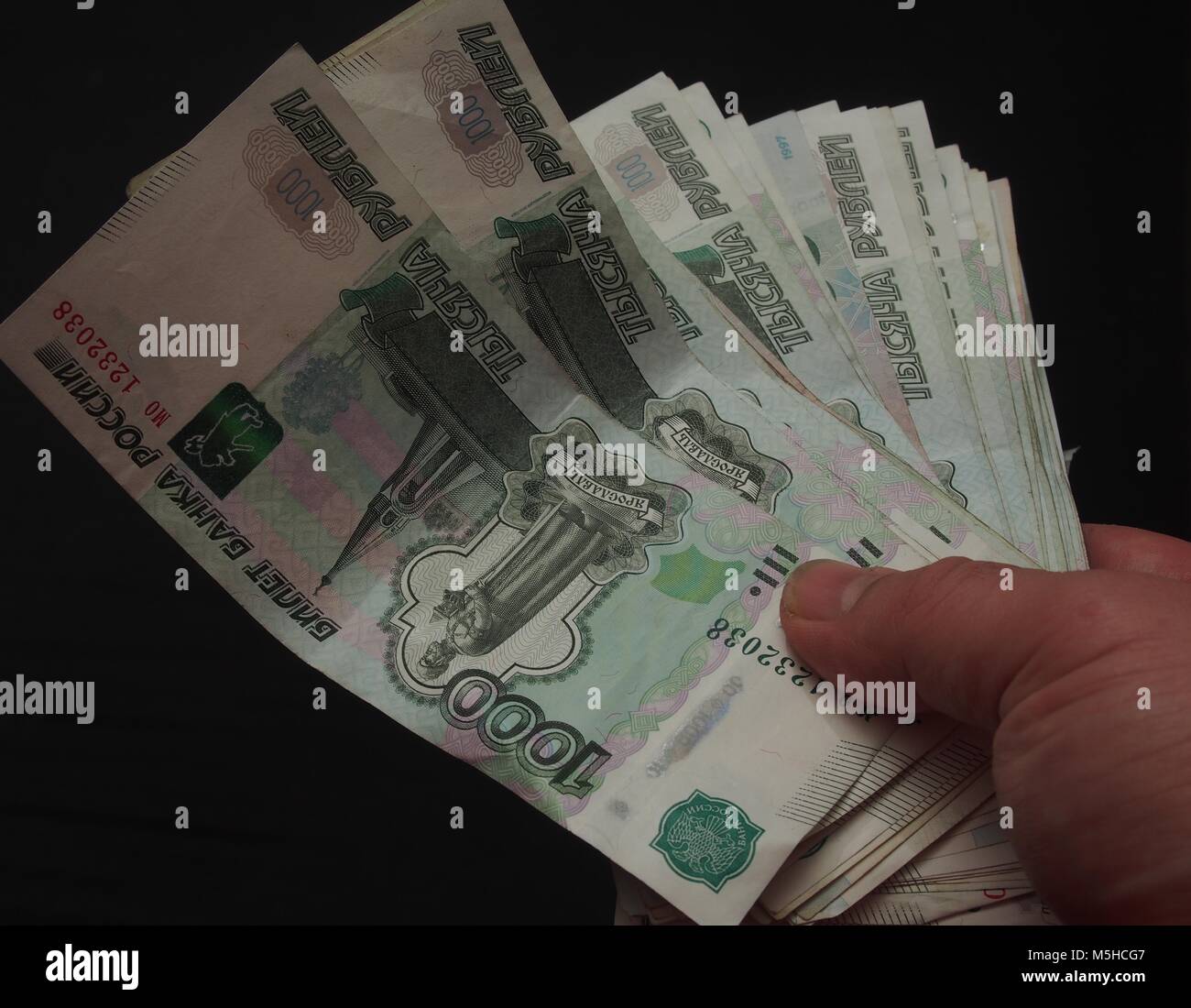 Banknoten im Wert von 1000 Rubel in der Hand einer Person. Das Geld ist ...