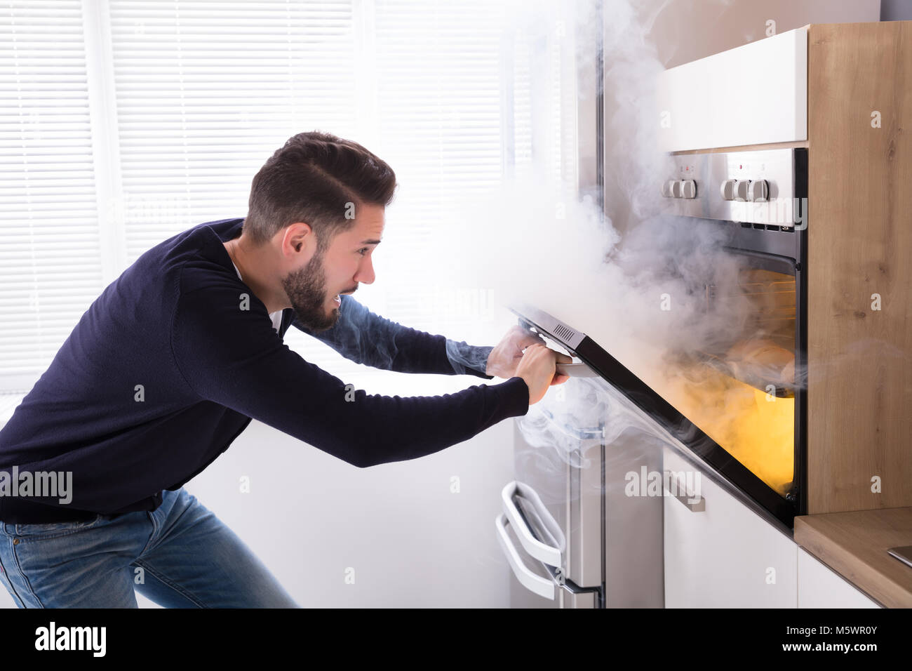Mann an Verbrannte Kekse mit Rauch aus Backofen Geschockt ...