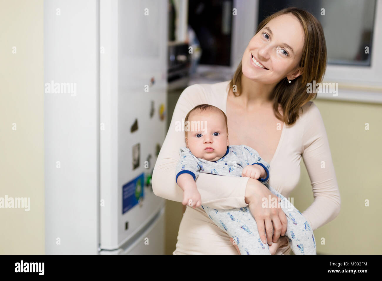 Junge schöne Mutter holding Sohn mit Händen. Nachdenklich hochmütig ...